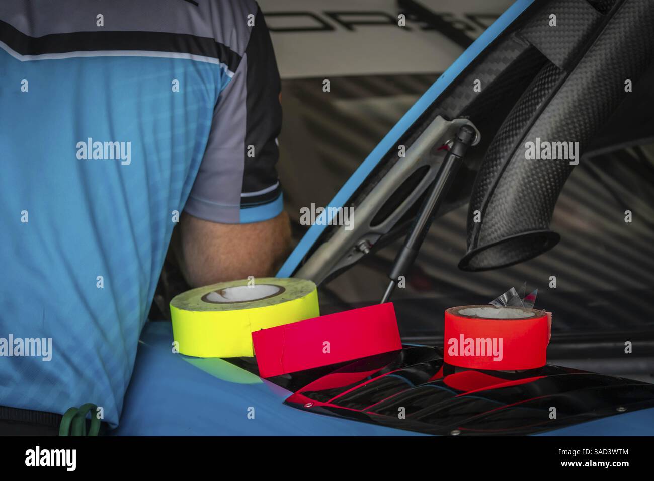 An engineer meticulously inspects the race car, fine-tuning key ...