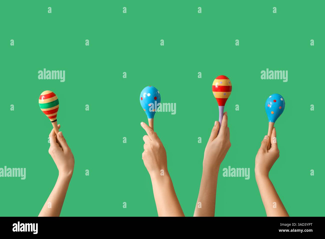 Female hands holding maracas on green background Stock Photo - Alamy