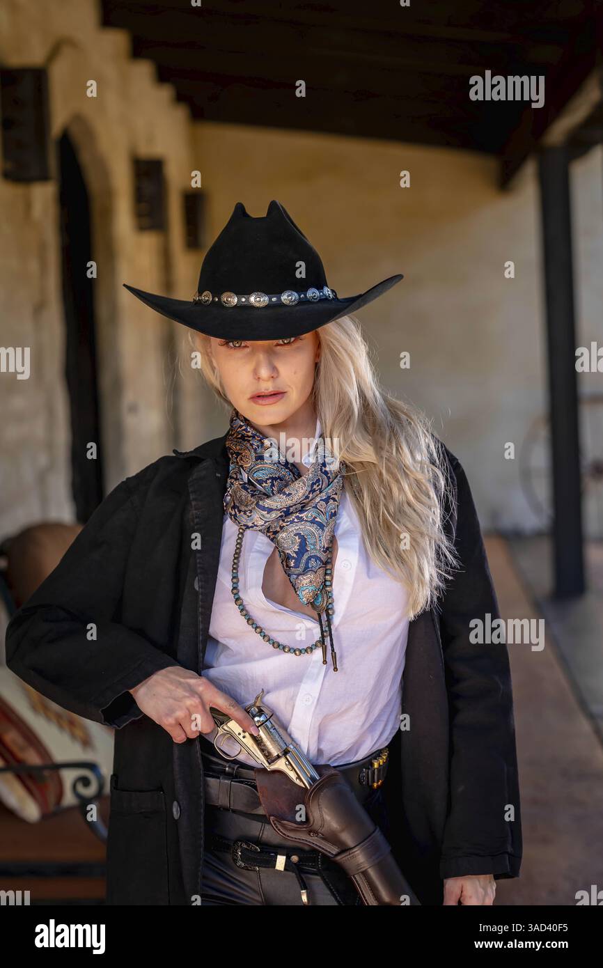 A confident, beautiful blonde woman in classic cowboy attire stands ...