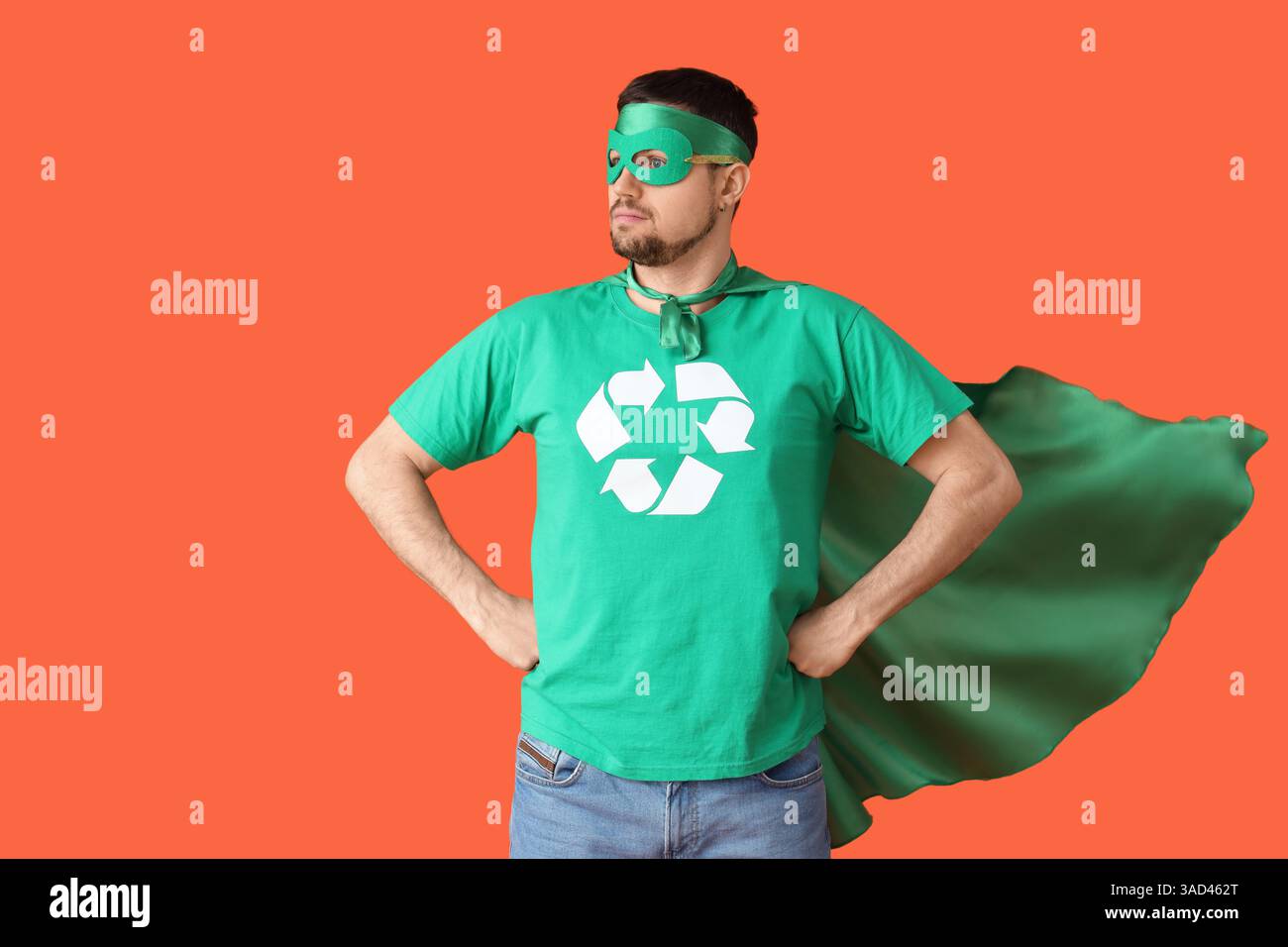 Young man dressed as eco superhero on orange background. Ecology ...