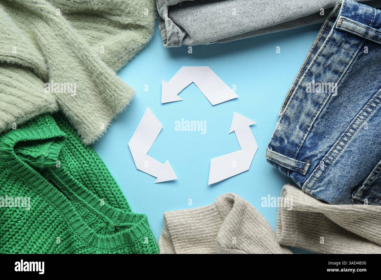 Clothes with recycling logo on blue background Stock Photo - Alamy