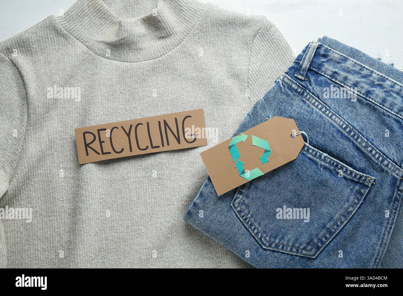 Clothes with recycling signs on white wooden background Stock Photo - Alamy