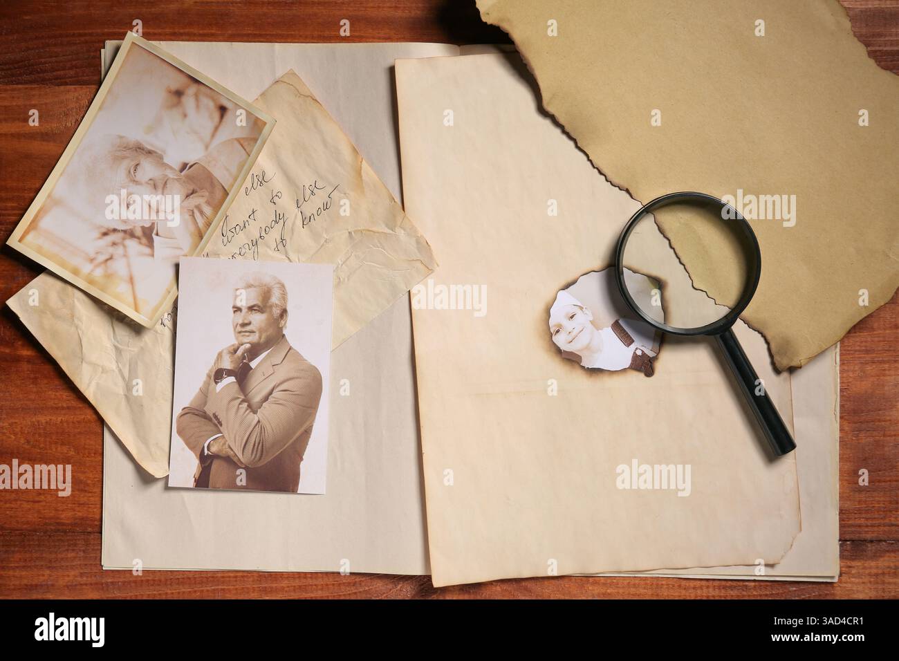 Old photos of relatives with letter and magnifier on wooden background ...