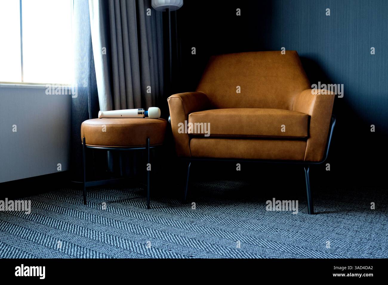 Cordless wand vibrator resting on a cushioned table next to a chair in ...