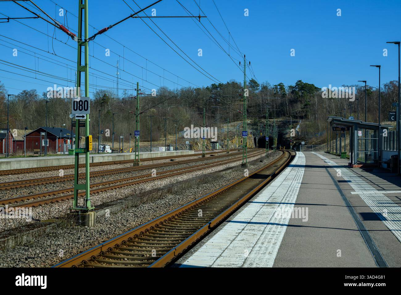 A train station shows empty platforms and railway tracks stretching ...