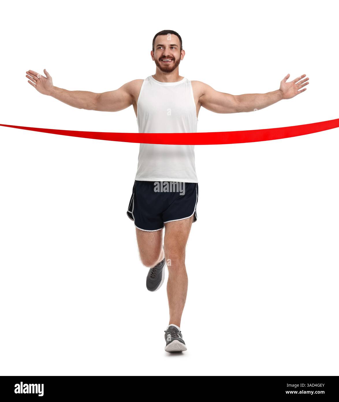 Happy sportsman crossing red finish line ribbon on white background ...