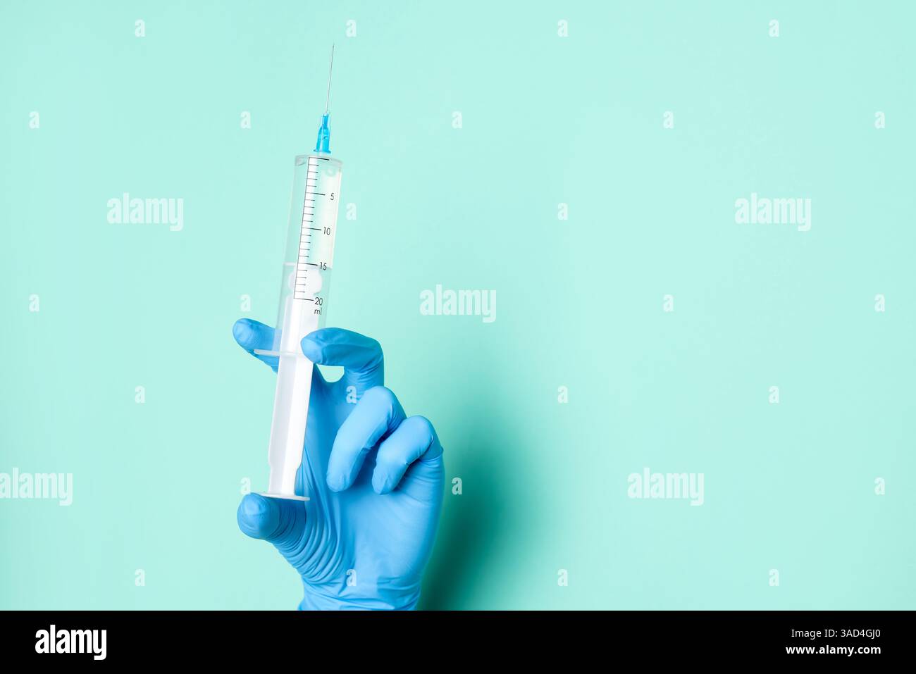 Doctor holding syringe with medication on turquoise background, closeup ...