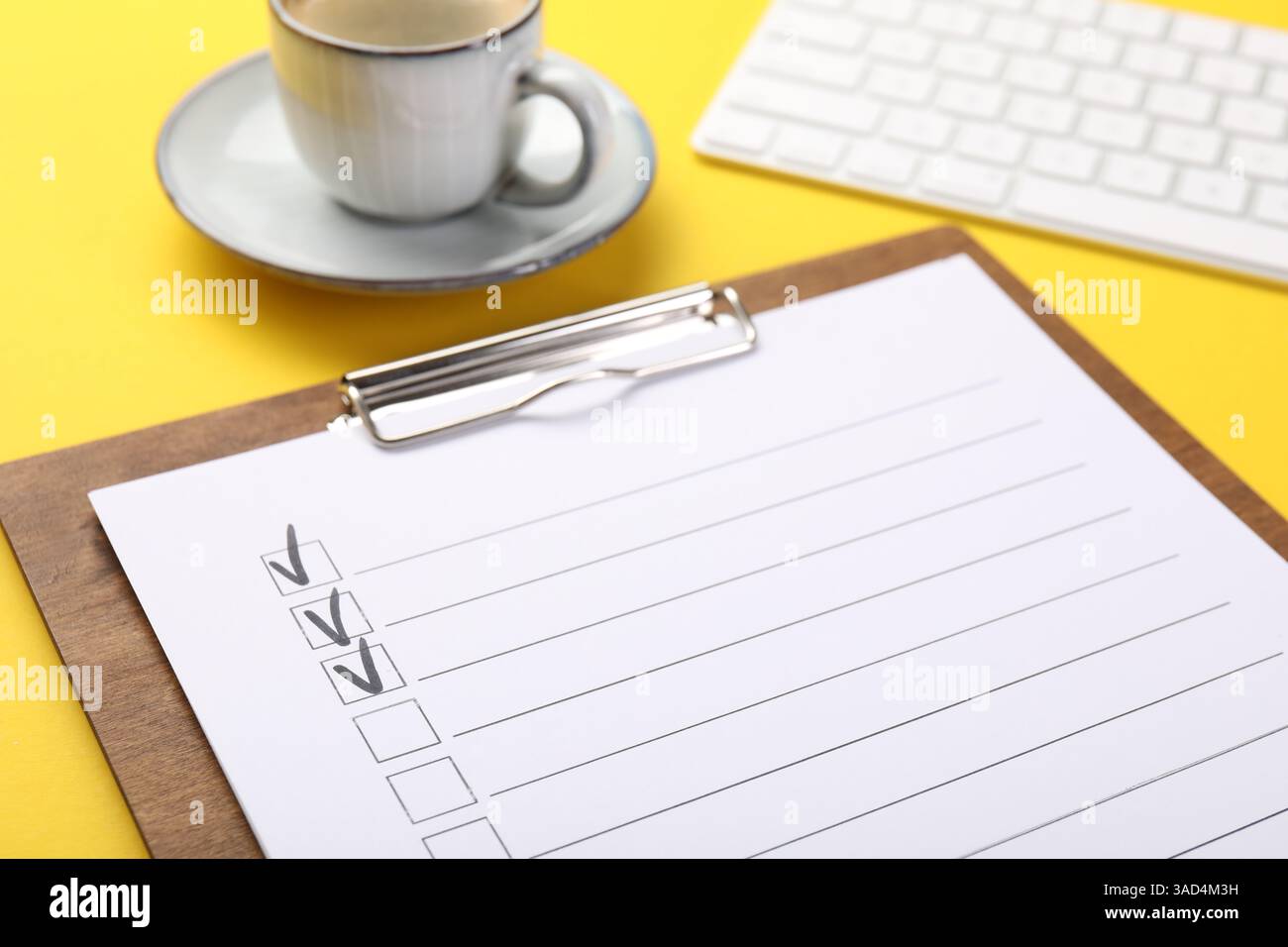 Checklist, coffee and keyboard on yellow background, closeup Stock ...