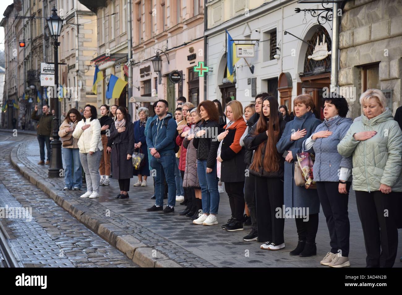People sing the anthem during the National Anthem Day of Ukraine at Rynok Square. Every year on ...