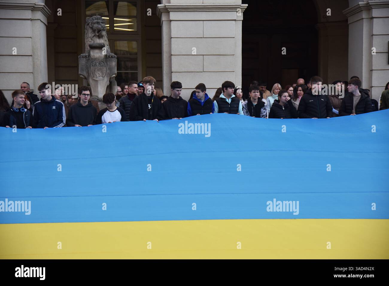 Children hold a large unfurled flag of Ukraine during the National Anthem Day of Ukraine at ...