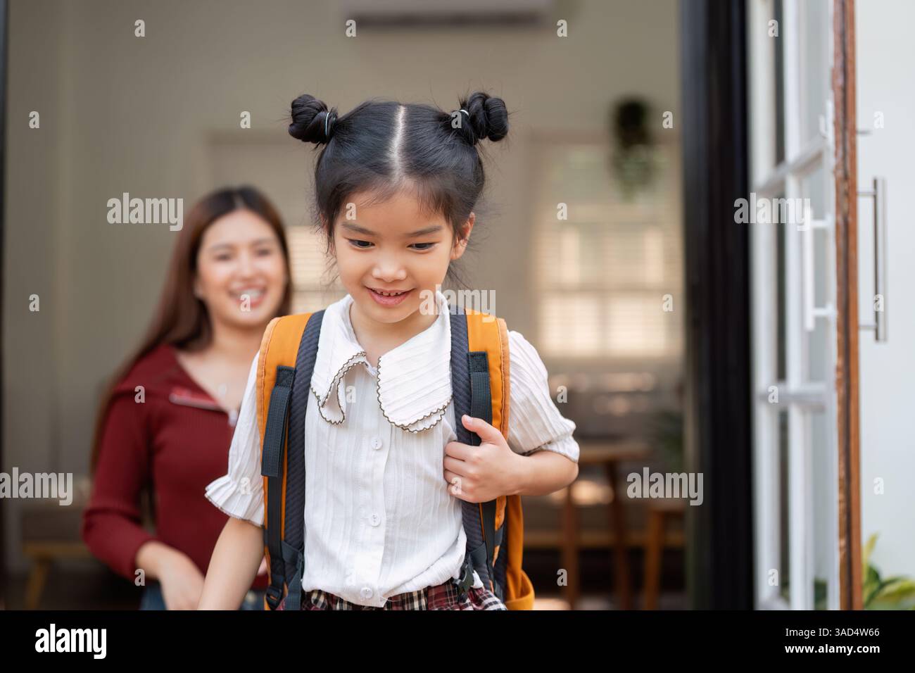 Exciting School Departure. A girl steps out happily with her mother ...