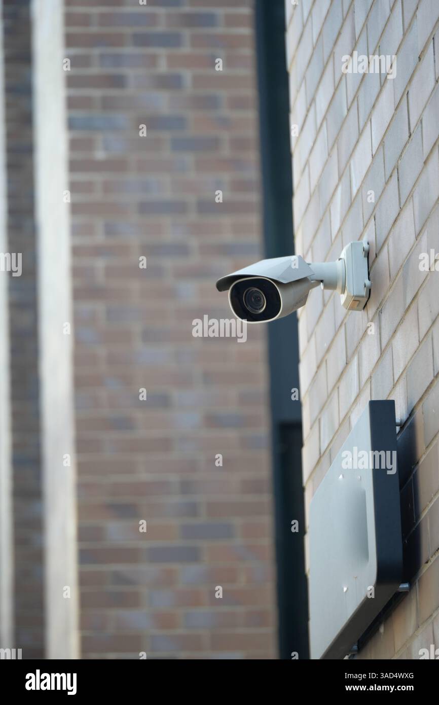 Security camera mounted on a brick wall beside an entrance Stock Photo ...
