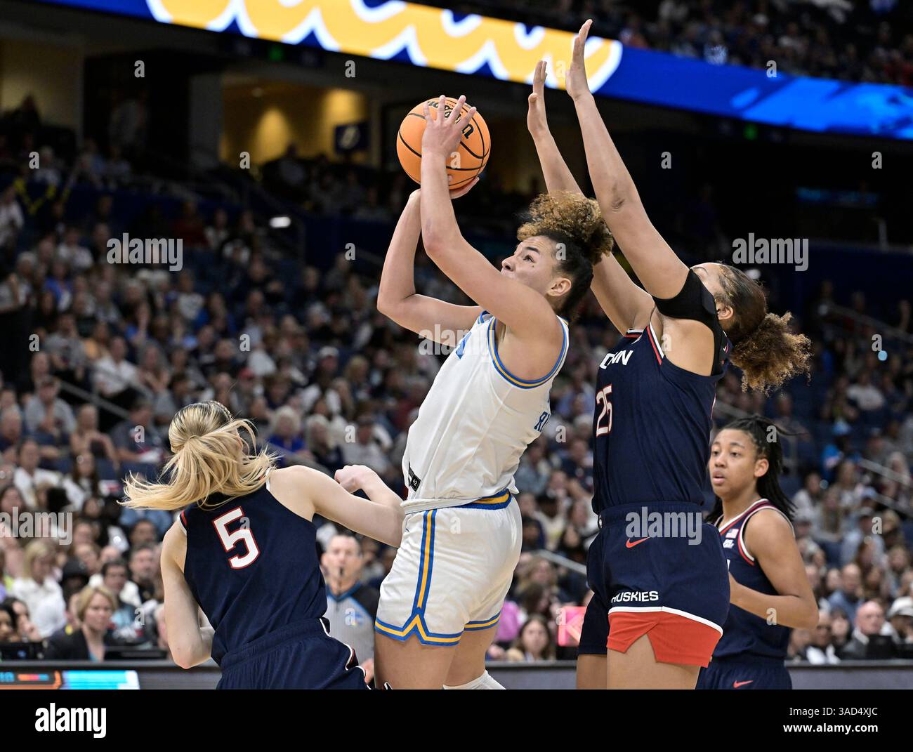 UCLA guard Kiki Rice (1) shoots as she is guarded by UConn guard Paige ...