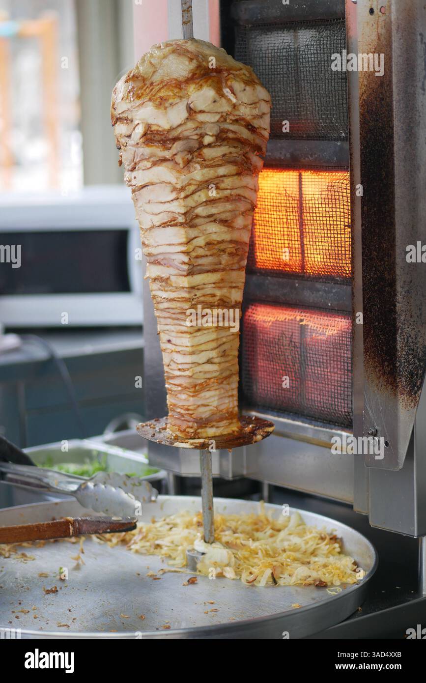 Savory shawarma cooking on a vertical spit in a food stall Stock Photo ...