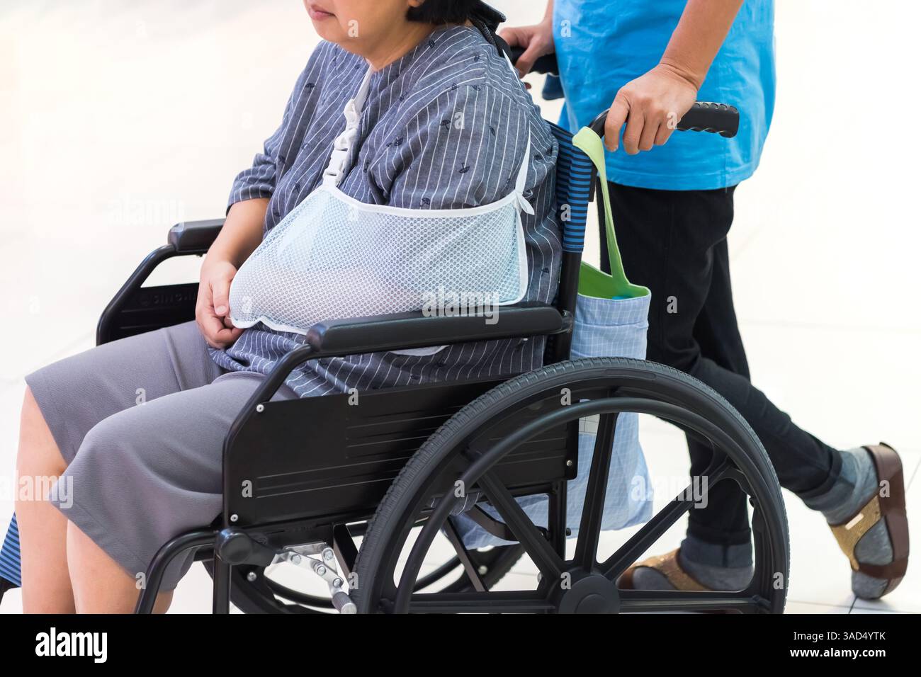 Patient elderly woman with arm injury on wheelchair waiting a doctor ...
