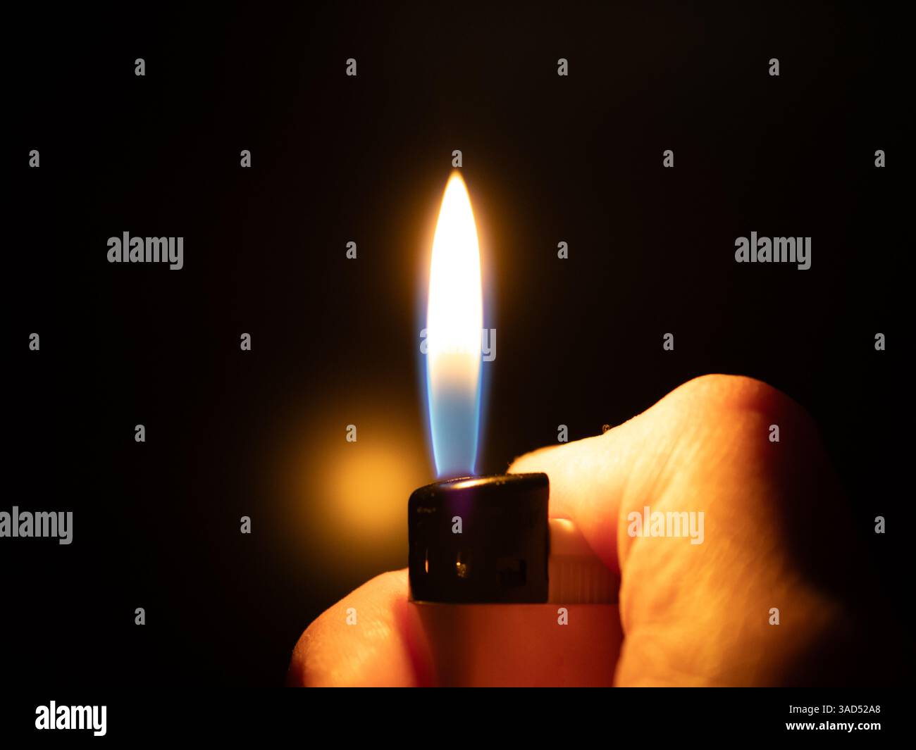 A flaming lighter in hand amidst the darkness Stock Photo - Alamy