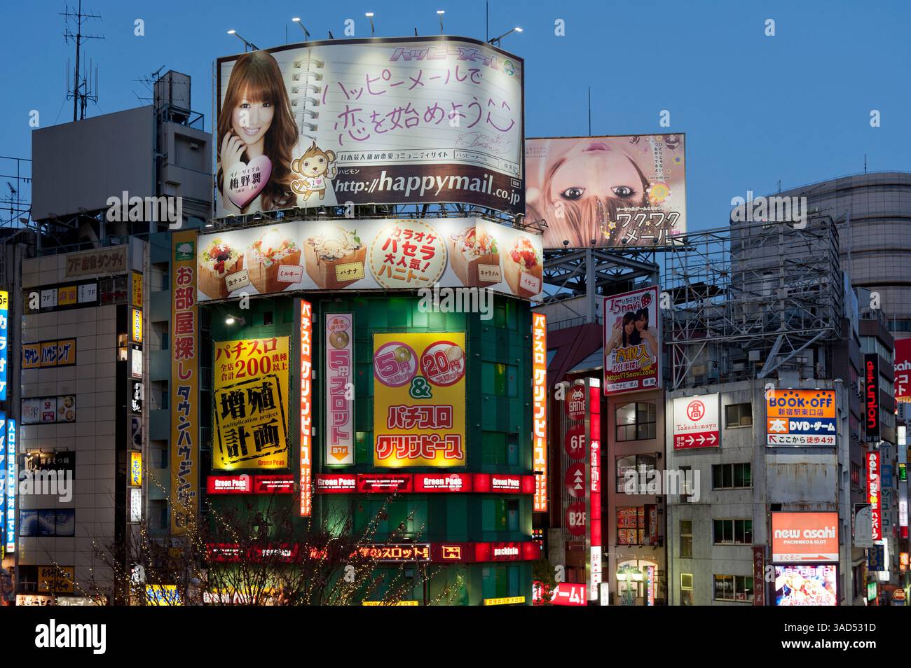 Neon signs light up the building facades in the Minami Shinjuku ...