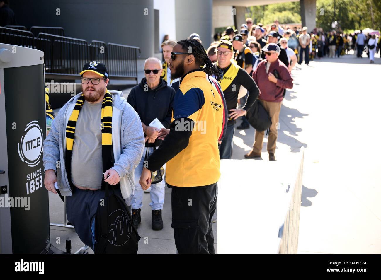 Security workers guide guests as the pass through security gates on ...