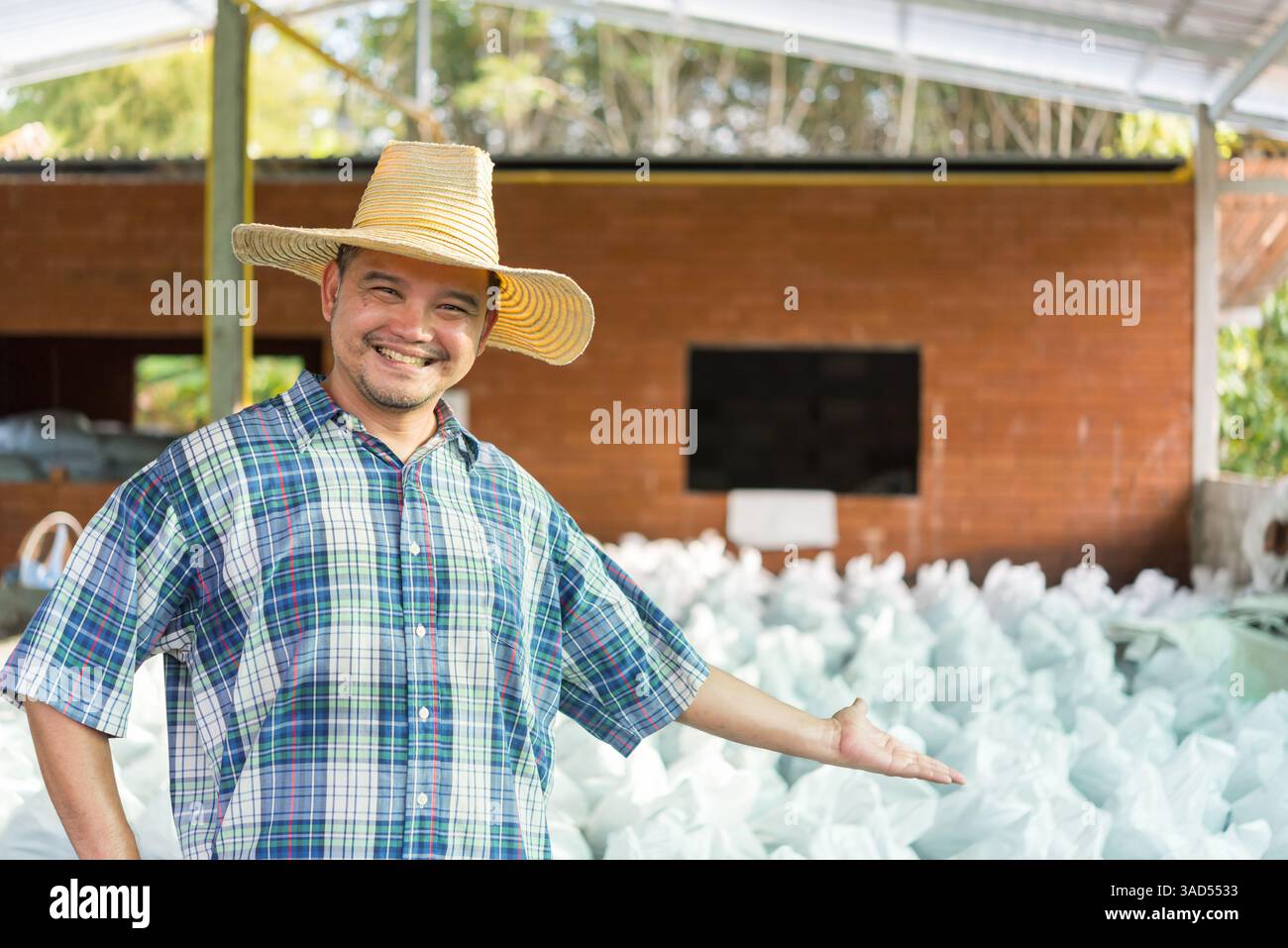 Asian man farmer agriculturist happy at a Fertilizer composting plant ...