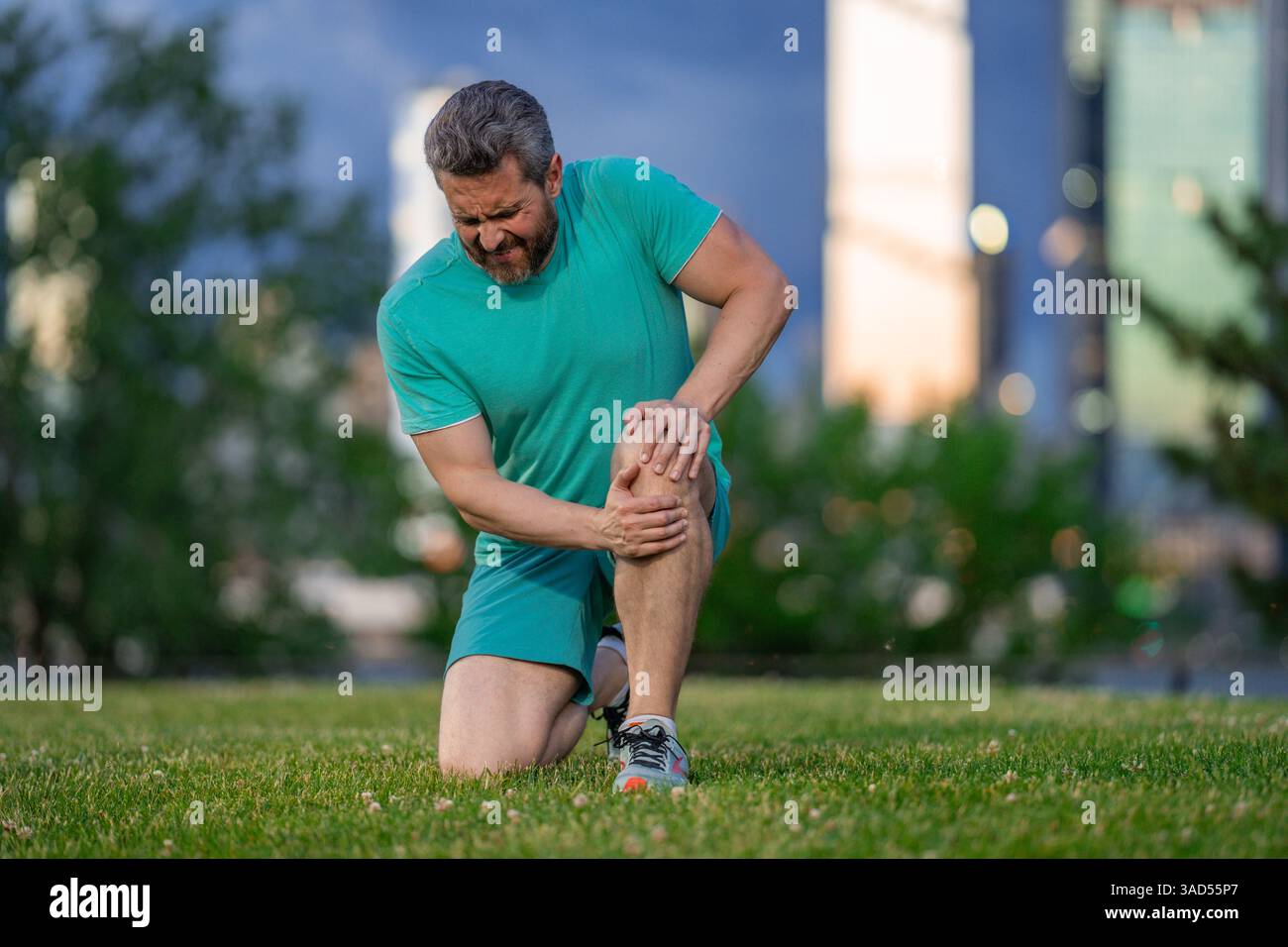 Broken knee after workout. Leg hurt during jogging. Injured man holding ...