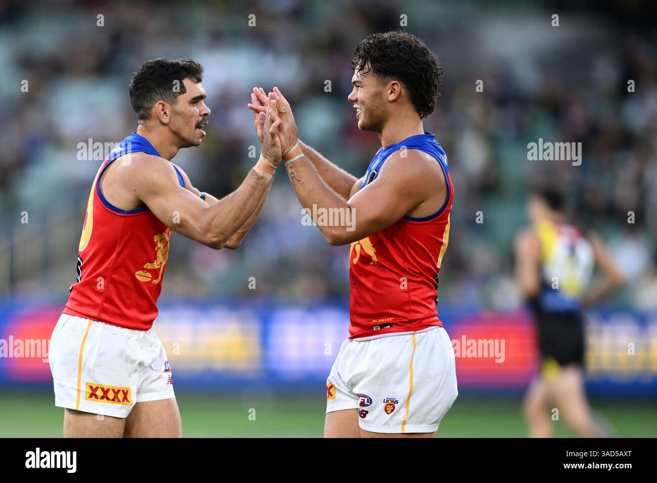 Charlie Cameron of the Lions (left) celebrates scoring a goal with Cam ...
