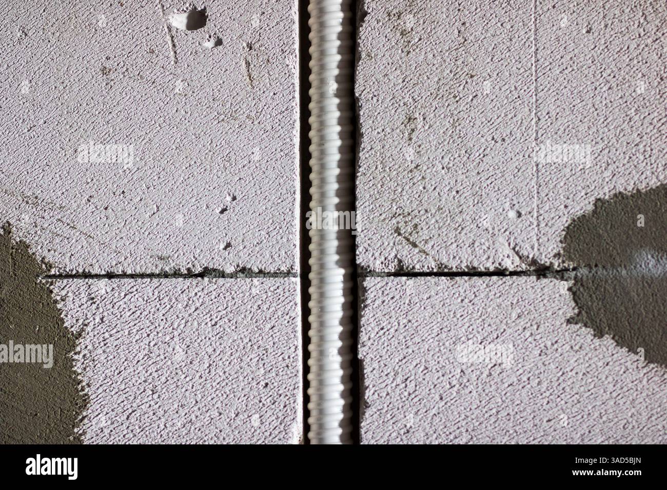 A close up view of a weathered concrete wall featuring a thin wire ...