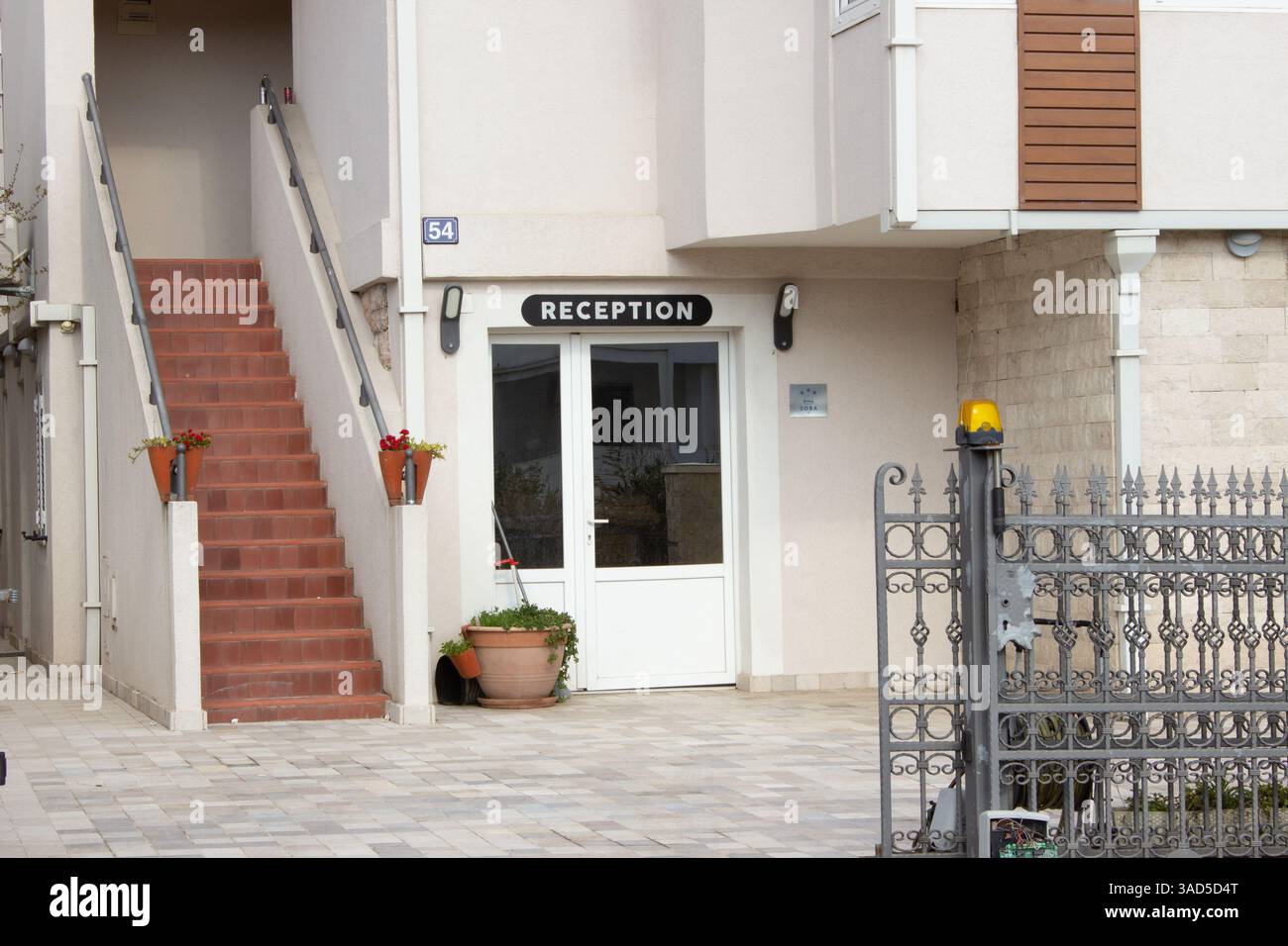 Modern hotel reception with exterior staircase and minimalist courtyard ...