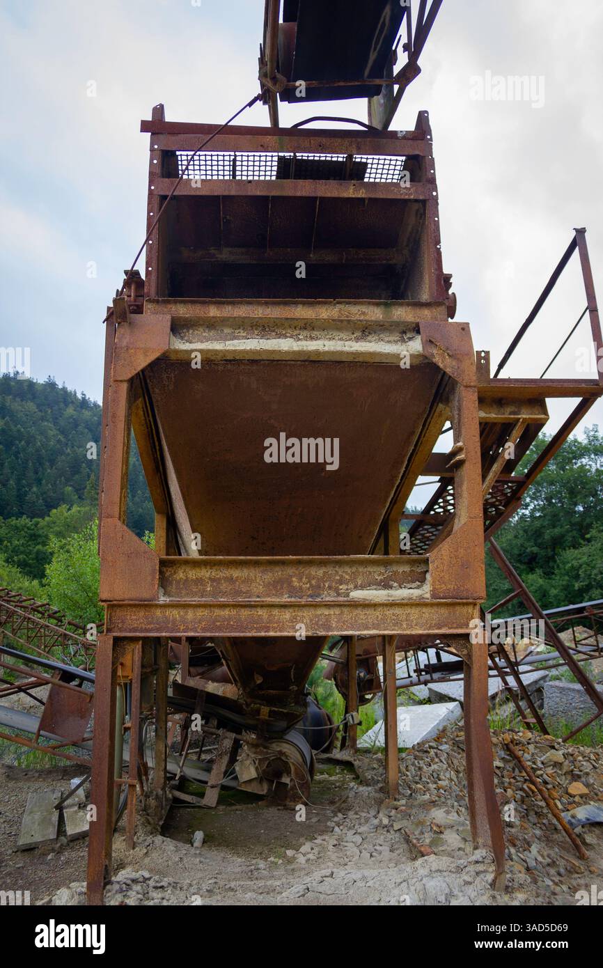 A large, rusted metal structure with a hole in the middle. The ...