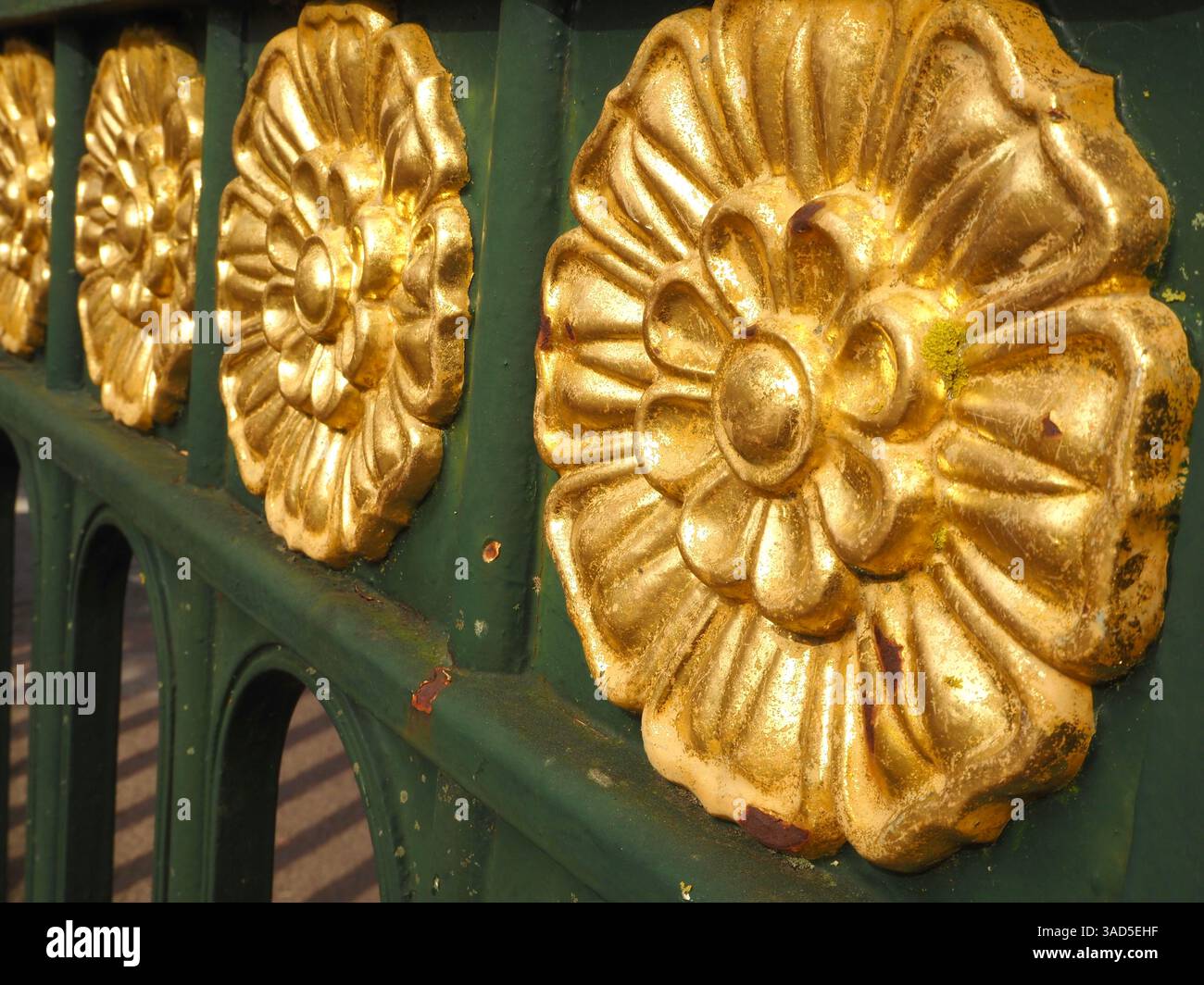 Gold painted cast iron roundel shapes depicting flower forms on gates ...