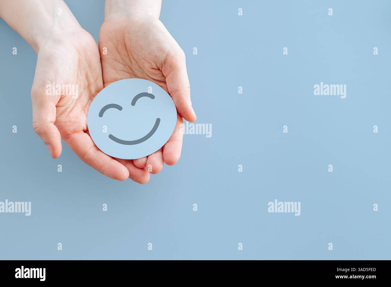 Hand holding a paper cut-out smile, positive thinking, emotional ...