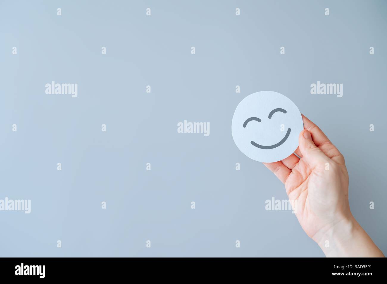 Hand holding a paper cut-out smile, positive thinking, emotional ...