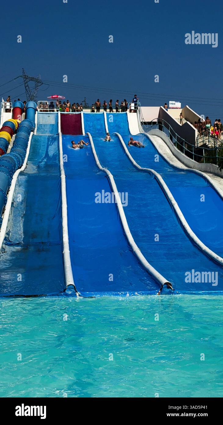 Athens, Greece - August 20, 2024: Exciting water slides leading into ...