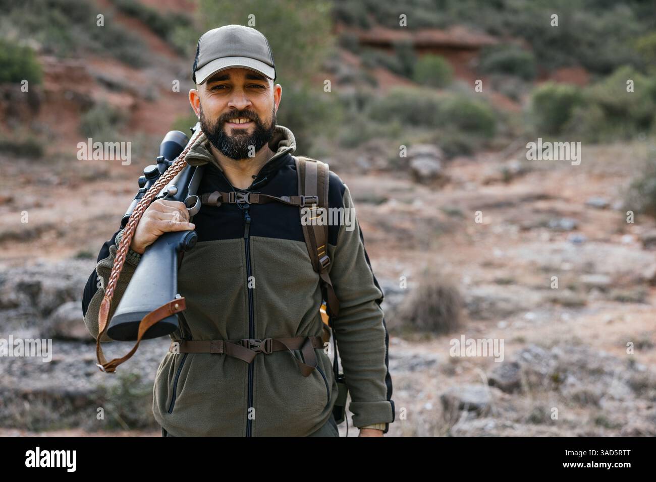Hunter smiling and holding rifle on shoulder in nature Stock Photo - Alamy