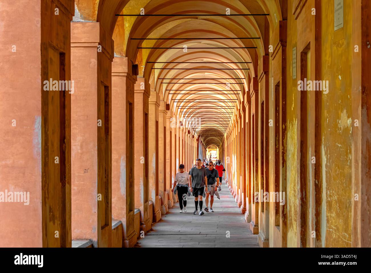 People walking along The Portico di San Luca in Bologna which stretches ...