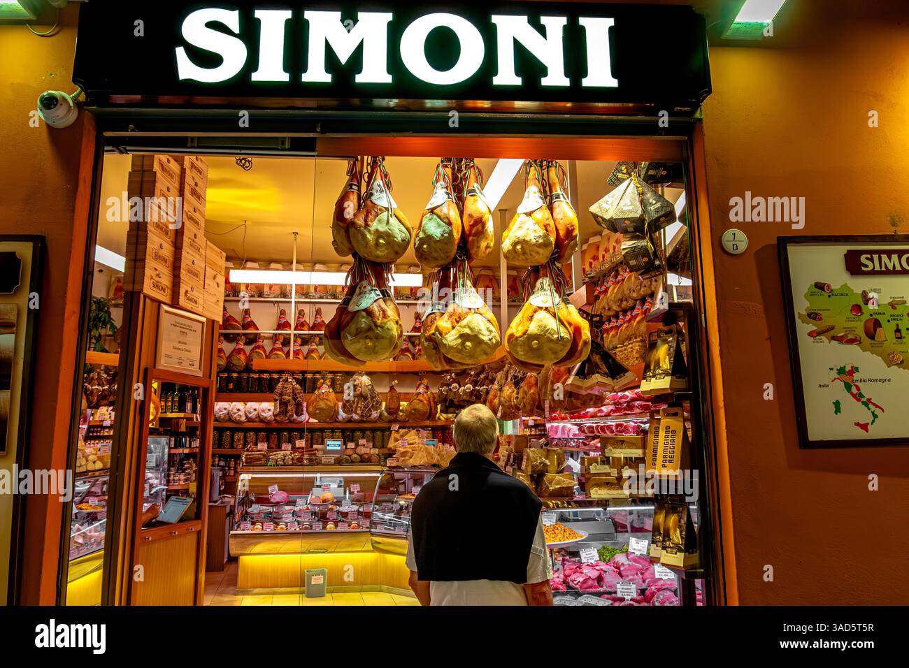 A man looking at the huge variety of cured meats on display at ...