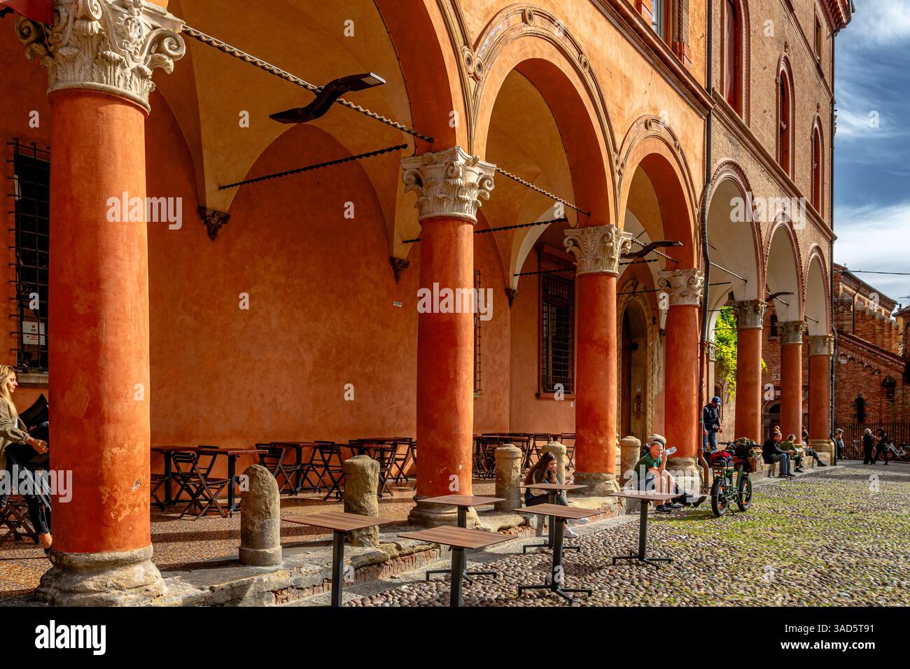 People sitting down outside under the Portico at the entrance to Corte ...