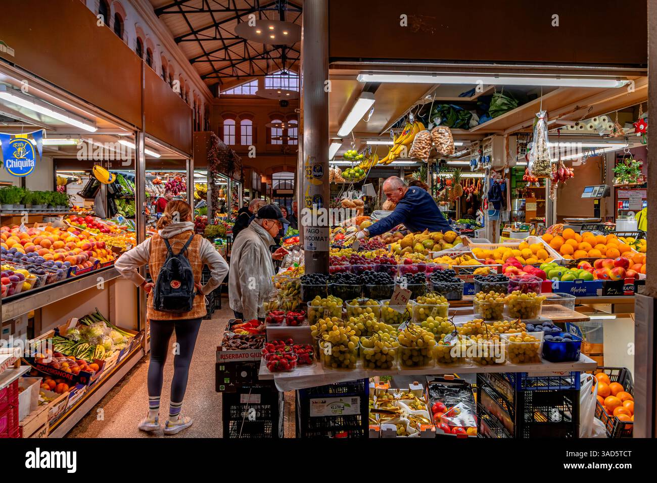 People shopping for fruit at a market stall in side Mercato delle Erbe ...