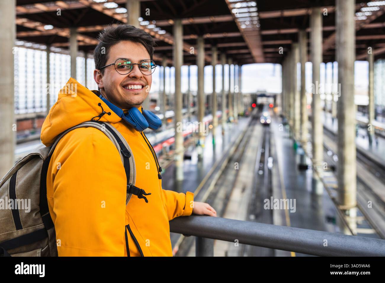 Young traveler smiling at train station, ready for new adventures Stock ...