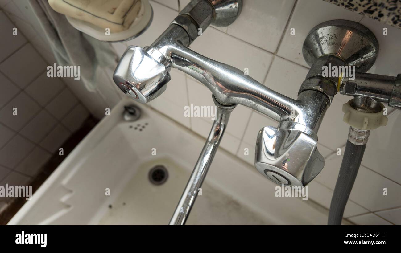 Chrome faucet detail over white sink in bathroom, showing plumbing ...