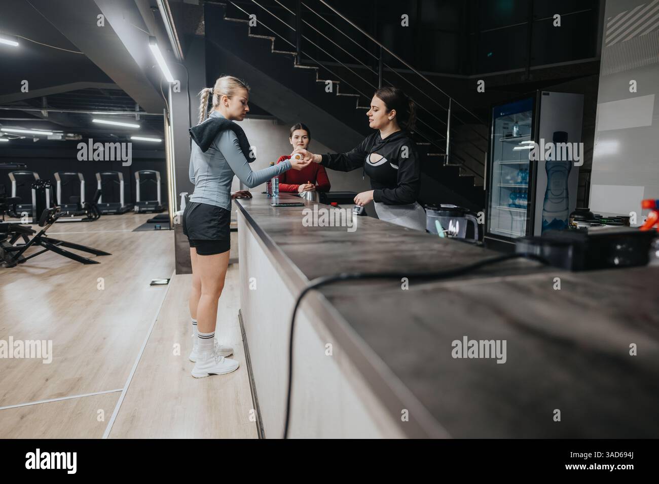 Women Interacting at a Gym Reception Counter While Having a ...