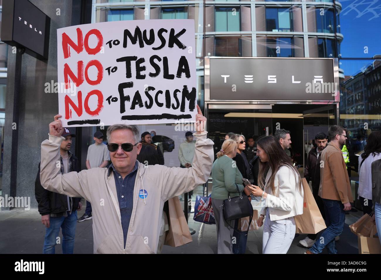 People take part in a protest outside a Tesla Pop-Up at Future Stores ...