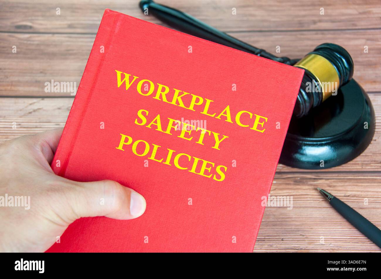 Hand holding Workplace Safety Policies book with gavel background. Harassment free concept Stock ...