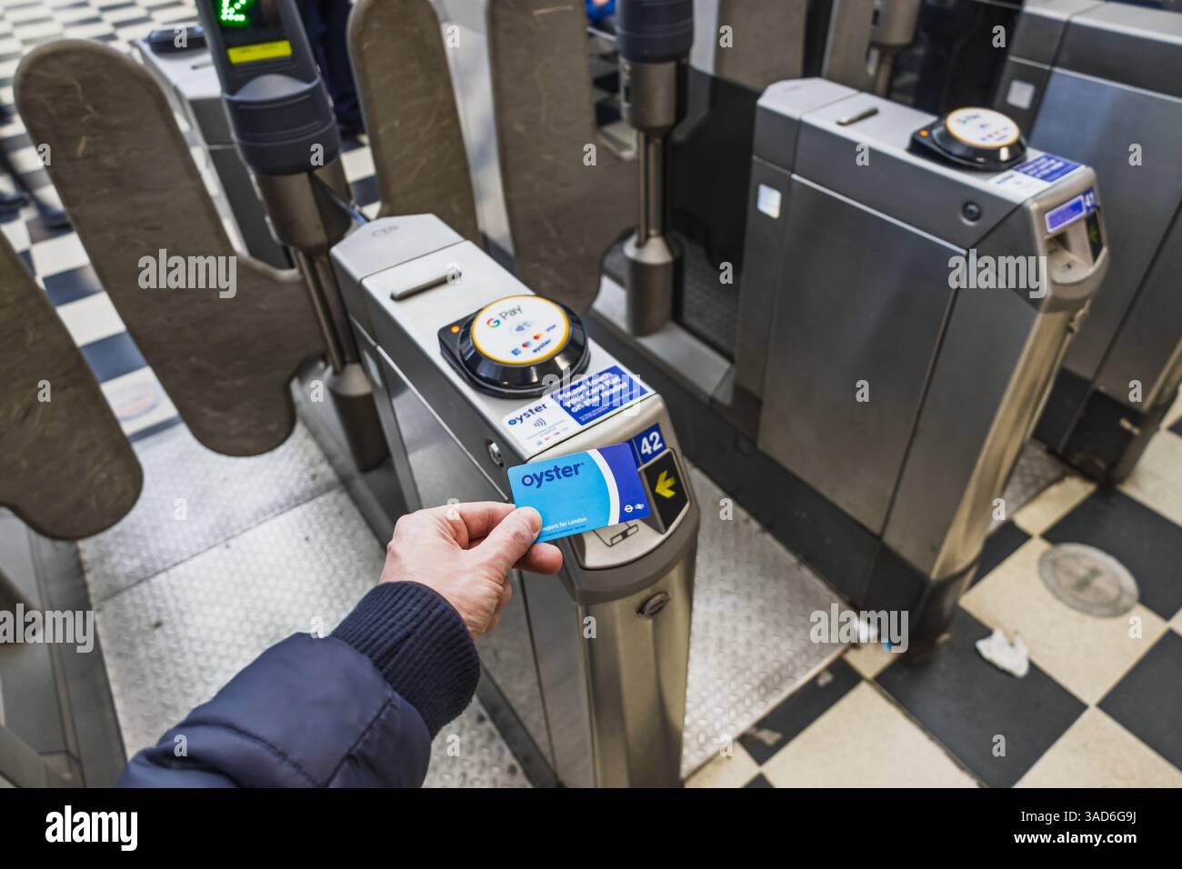 Passenger using Oyster card at London Underground turnstile gate ...