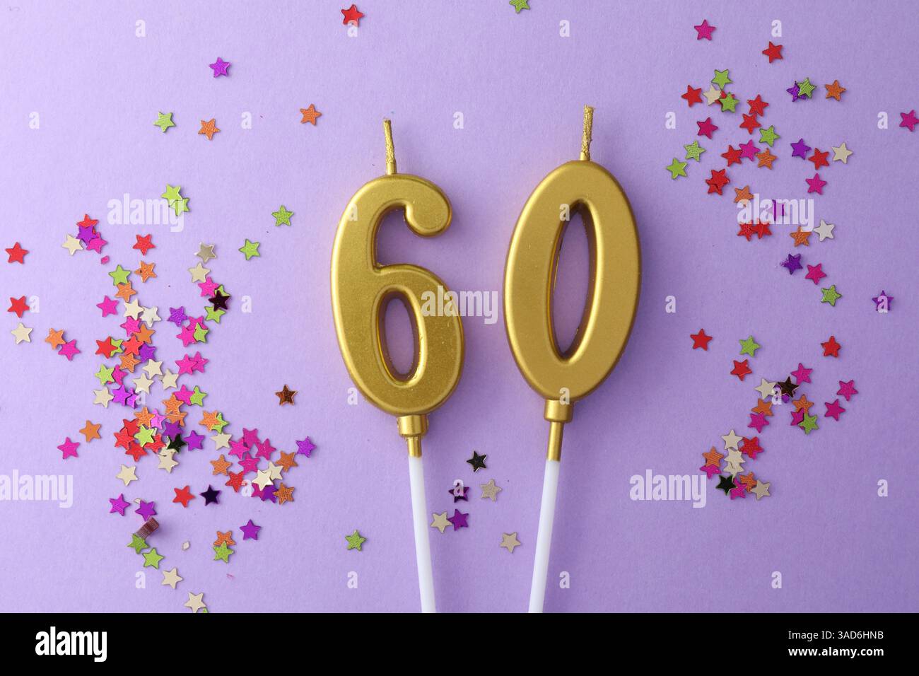 60th birthday. Number shaped candles and confetti on violet background ...