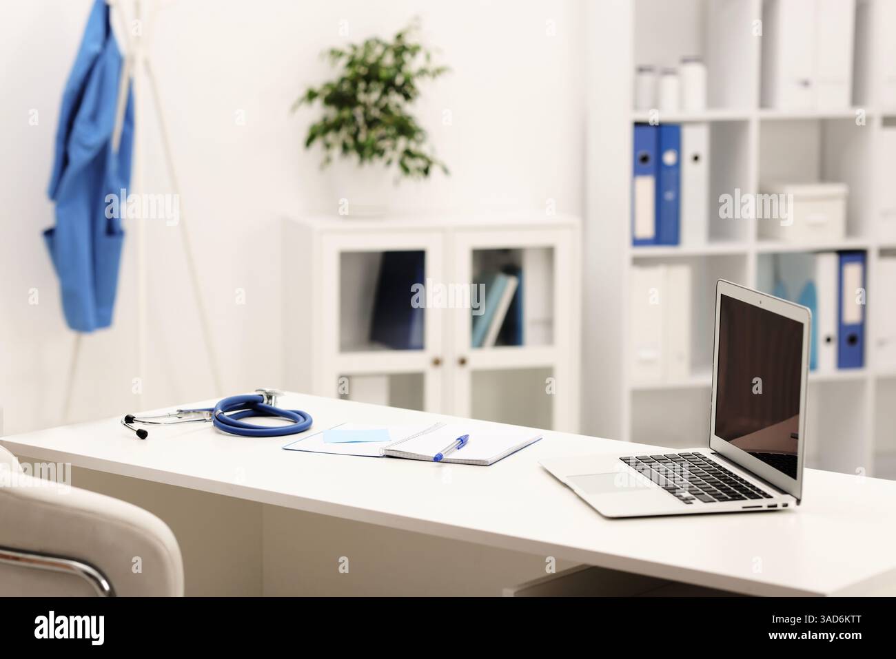 Doctor's workplace. Laptop, stethoscope and stationery on white table ...