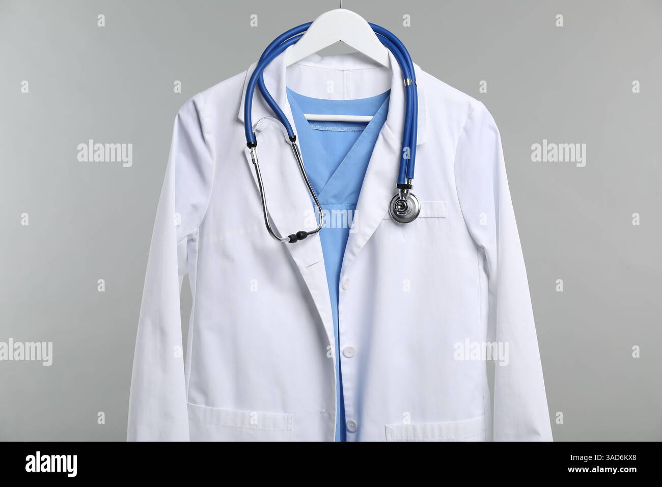 Doctor's coat with stethoscope on hanger against grey background Stock ...