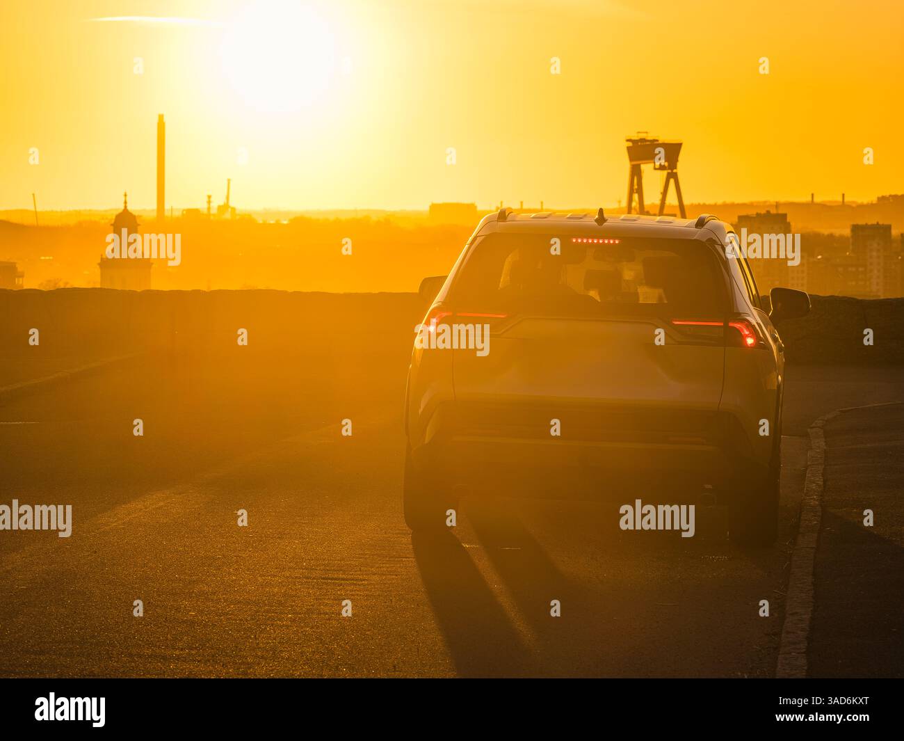 A car overlooks the breathtaking sunset in Gothenburg, where golden ...