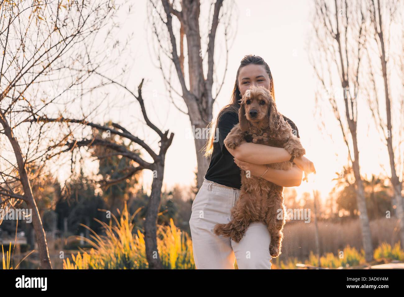A woman lovingly holds her cocker spaniel while enjoying a peaceful ...