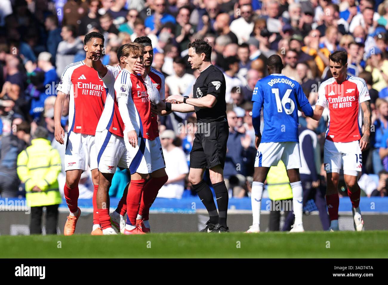 Arsenal players speak to referee Darren England (centre) after the ...