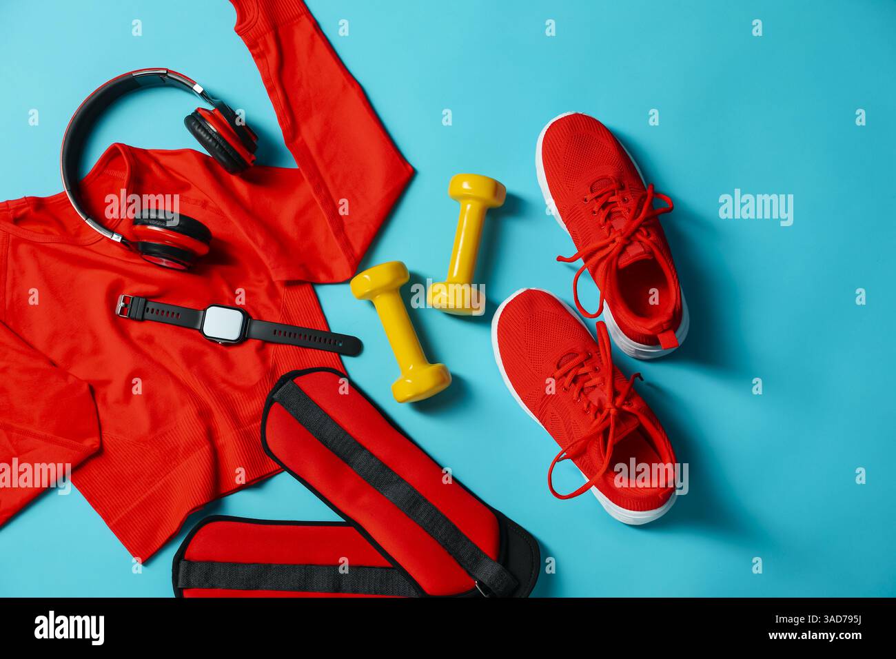 Different gym stuff, wrist watch and headphone on light blue background ...